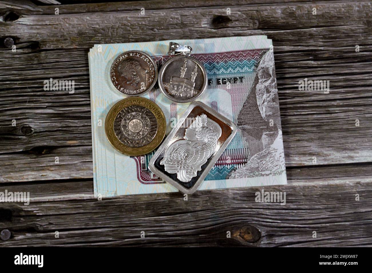 Two British sterling pounds coin, Egyptian pounds cash money with silver precious metal ounce ...