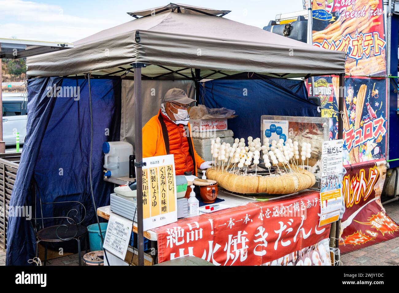A man selling traditional sticky rice balls on a food stand. Saitama ...