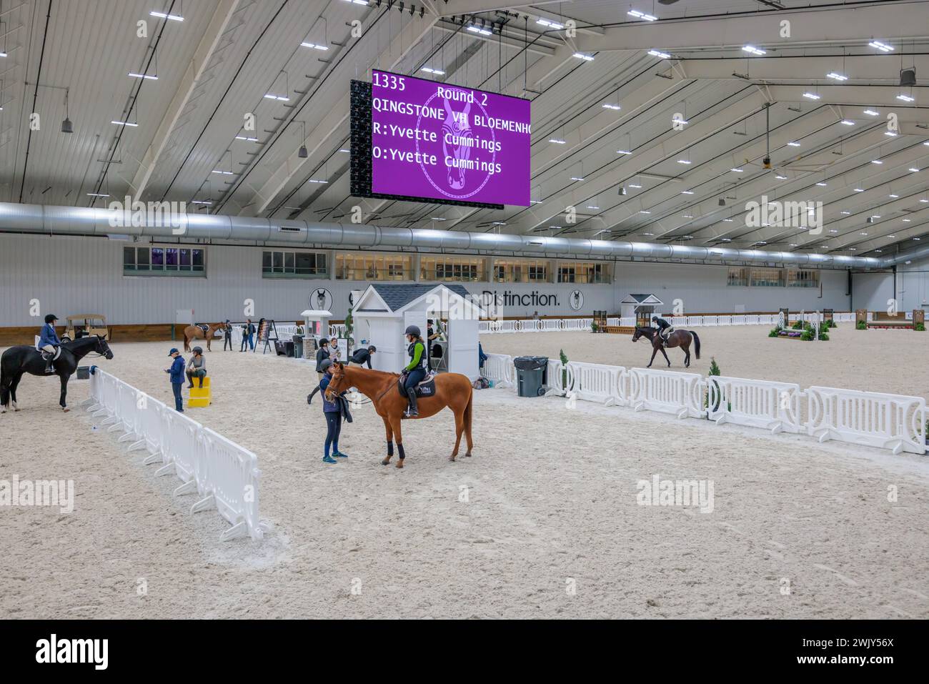 Riders prepare for hunter jumper competition at an indoor arena at the ...