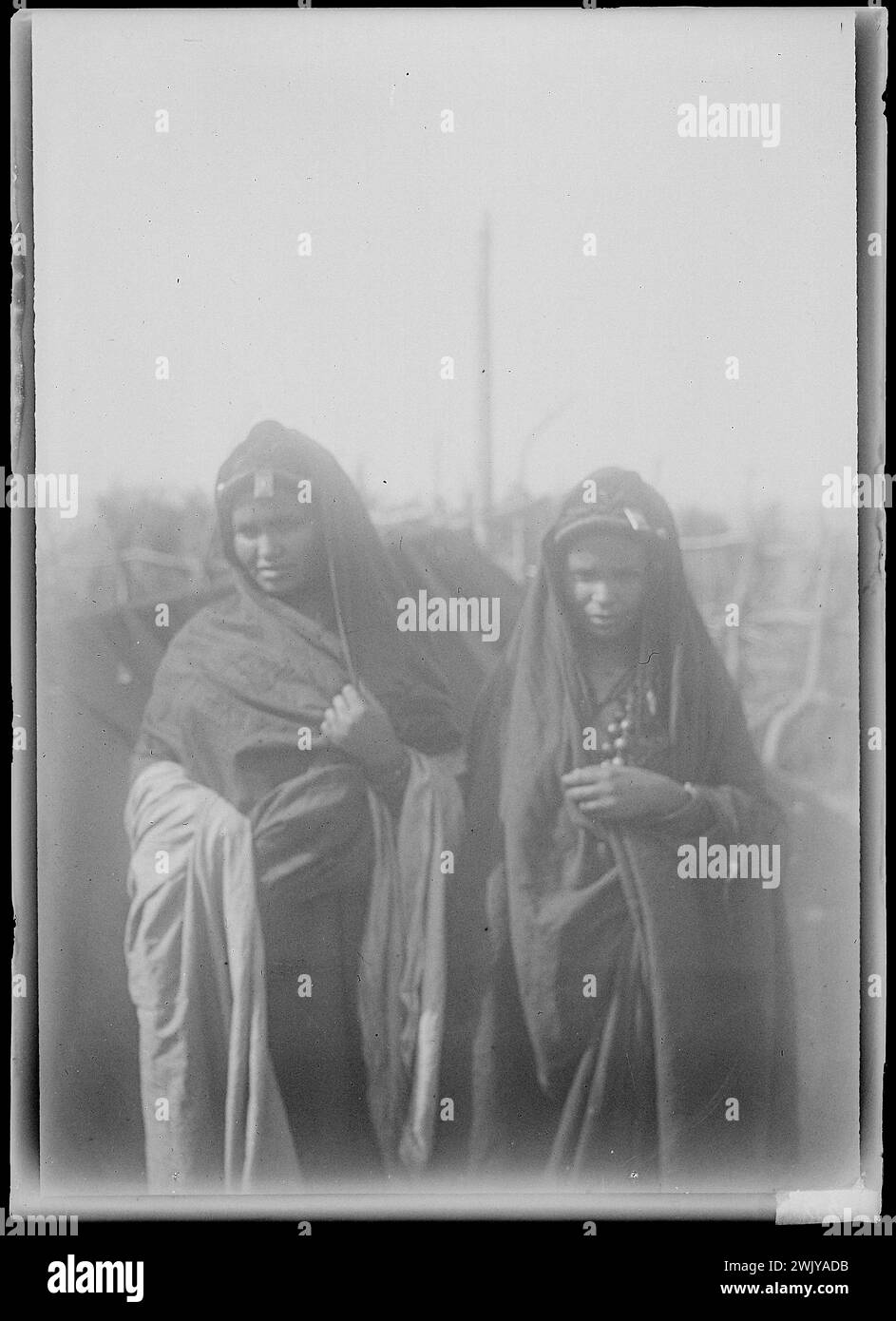 Two draped women posing in front of a camp. (Mid body view) (common ...