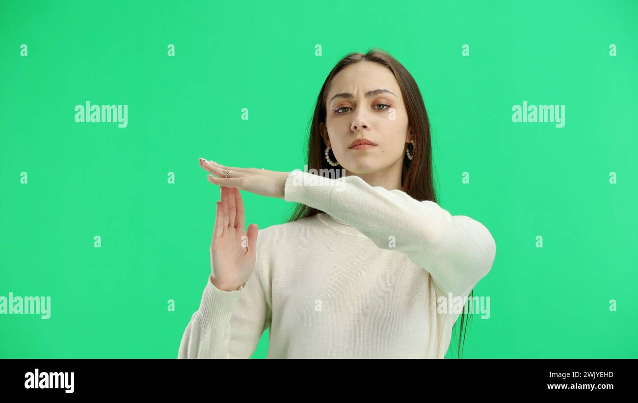 Woman, close-up, on a green background, showing a pause sign Stock ...