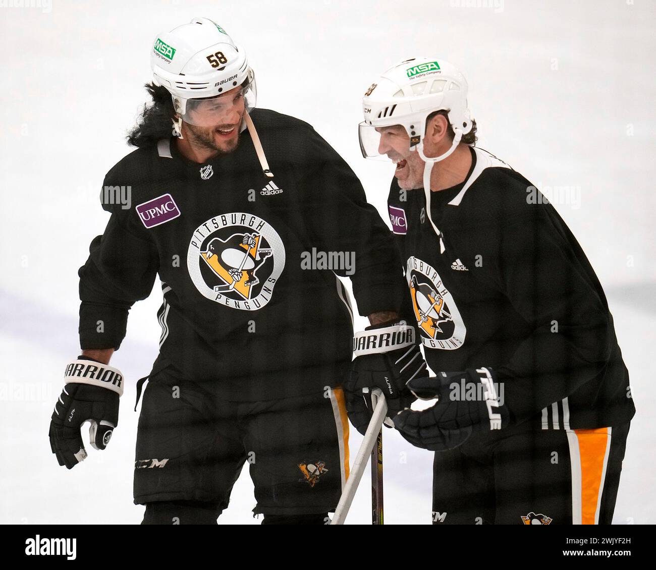 Pittsburgh Penguins' Kris Letang, left, wearing a mullet wig, shares a ...