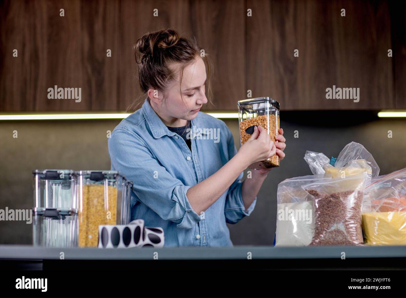Nice woman organizes the placement of food in plastic cans. Woman signs ...