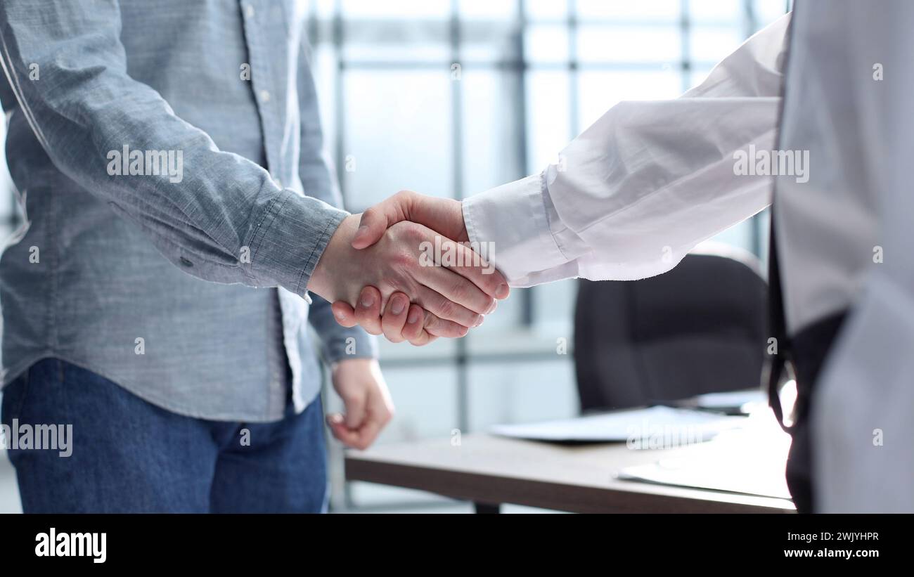 Office workers shake hands in the office Stock Photo - Alamy