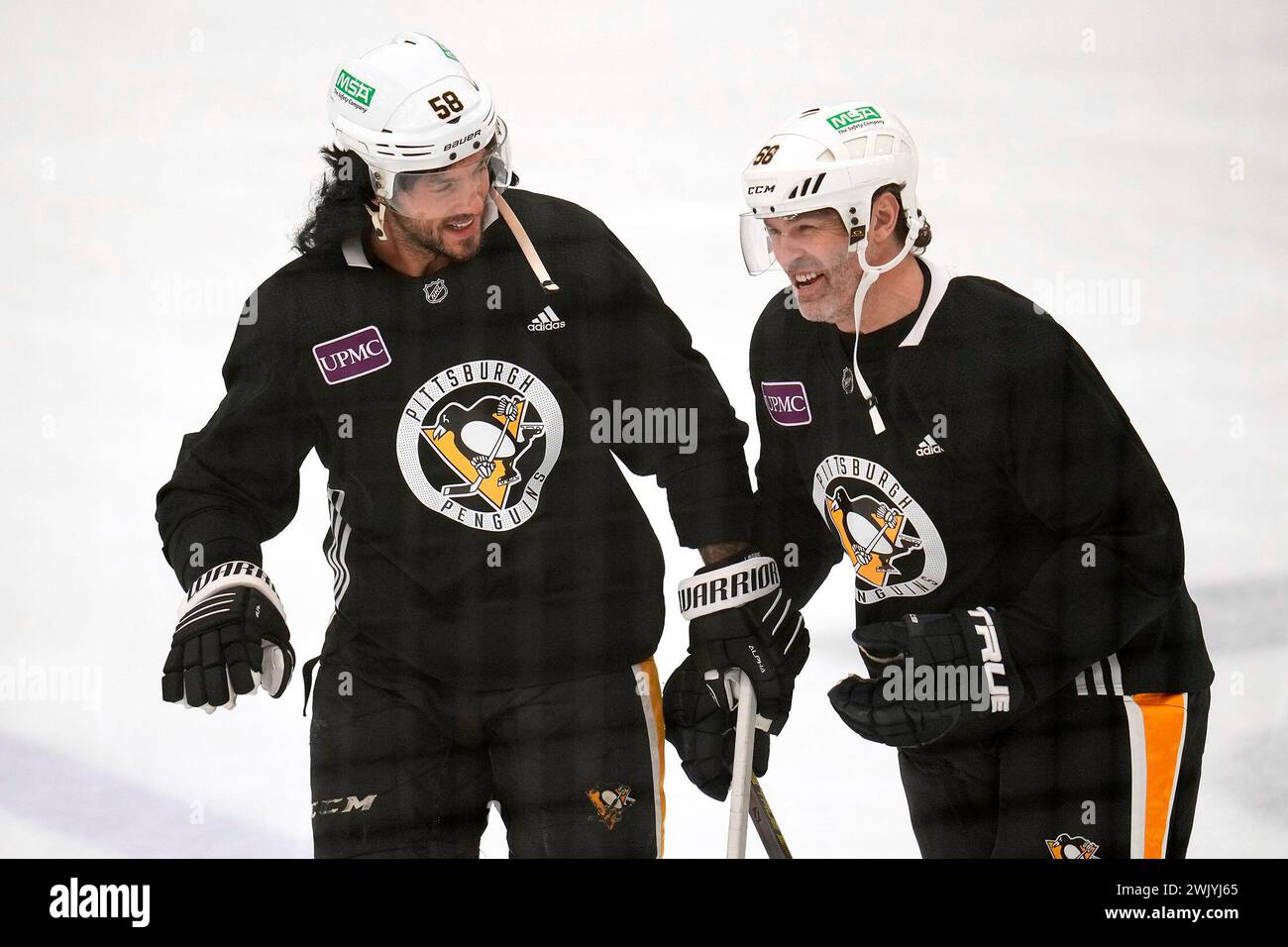 Pittsburgh Penguins' Kris Letang, left, shares a laugh, wearing a ...