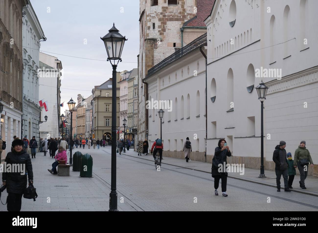 Tourists walk along pedestrianised Grodzka street in old Krakow, Poland ...