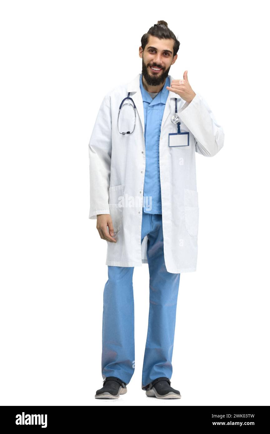 A male doctor, full-length, on a white background, shows a call sign ...