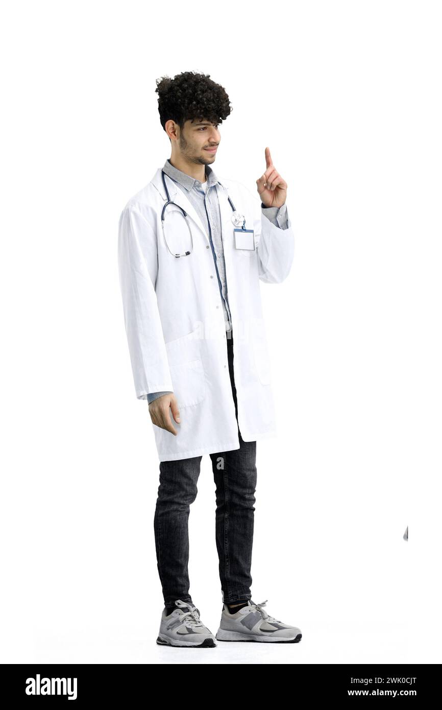 A male doctor, full-length, on a white background, shows an important ...
