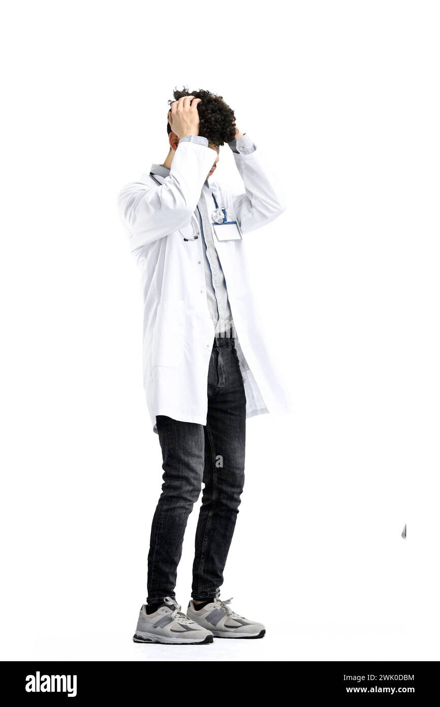 The male doctor, in full height, on a white background, clutched his ...