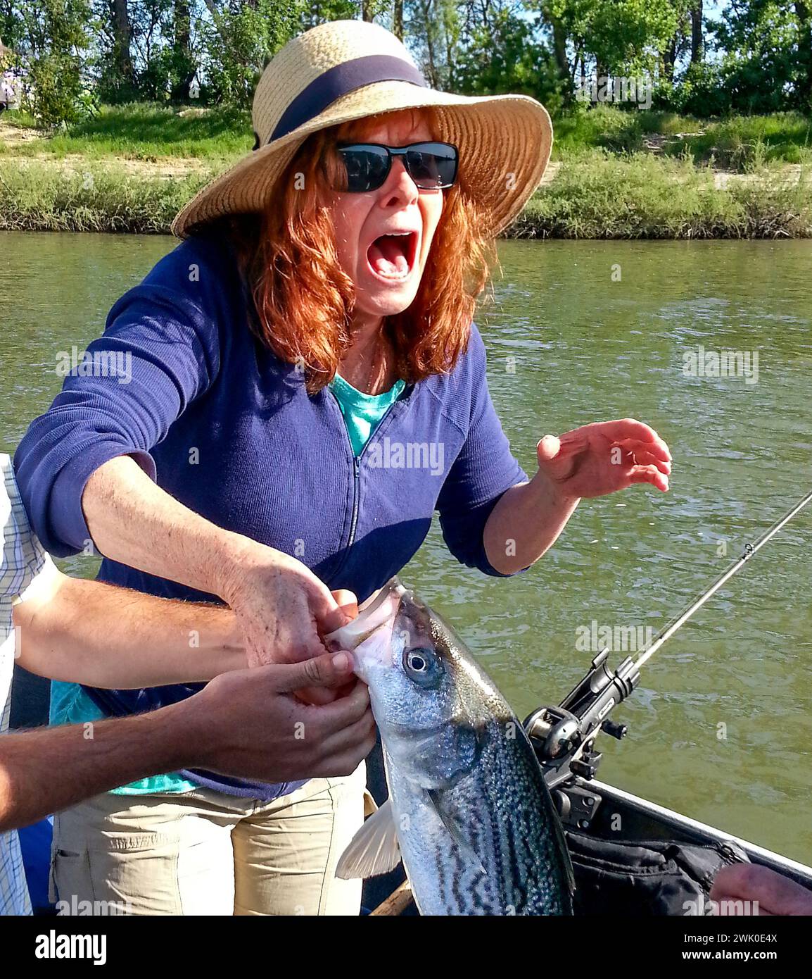 Fishing humor with a woman in a hat shows terror and excitement over ...