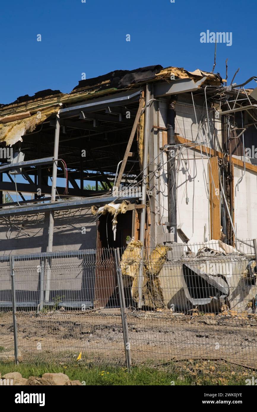 Partially demolished commercial building behind security fence Stock ...