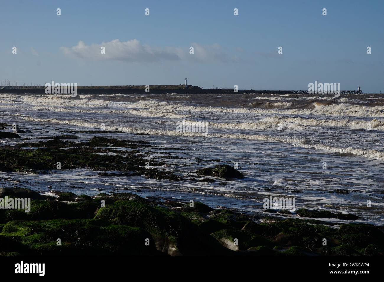 The harbour with Spring Tidal waves over the beach at Maryport, Cumbria ...