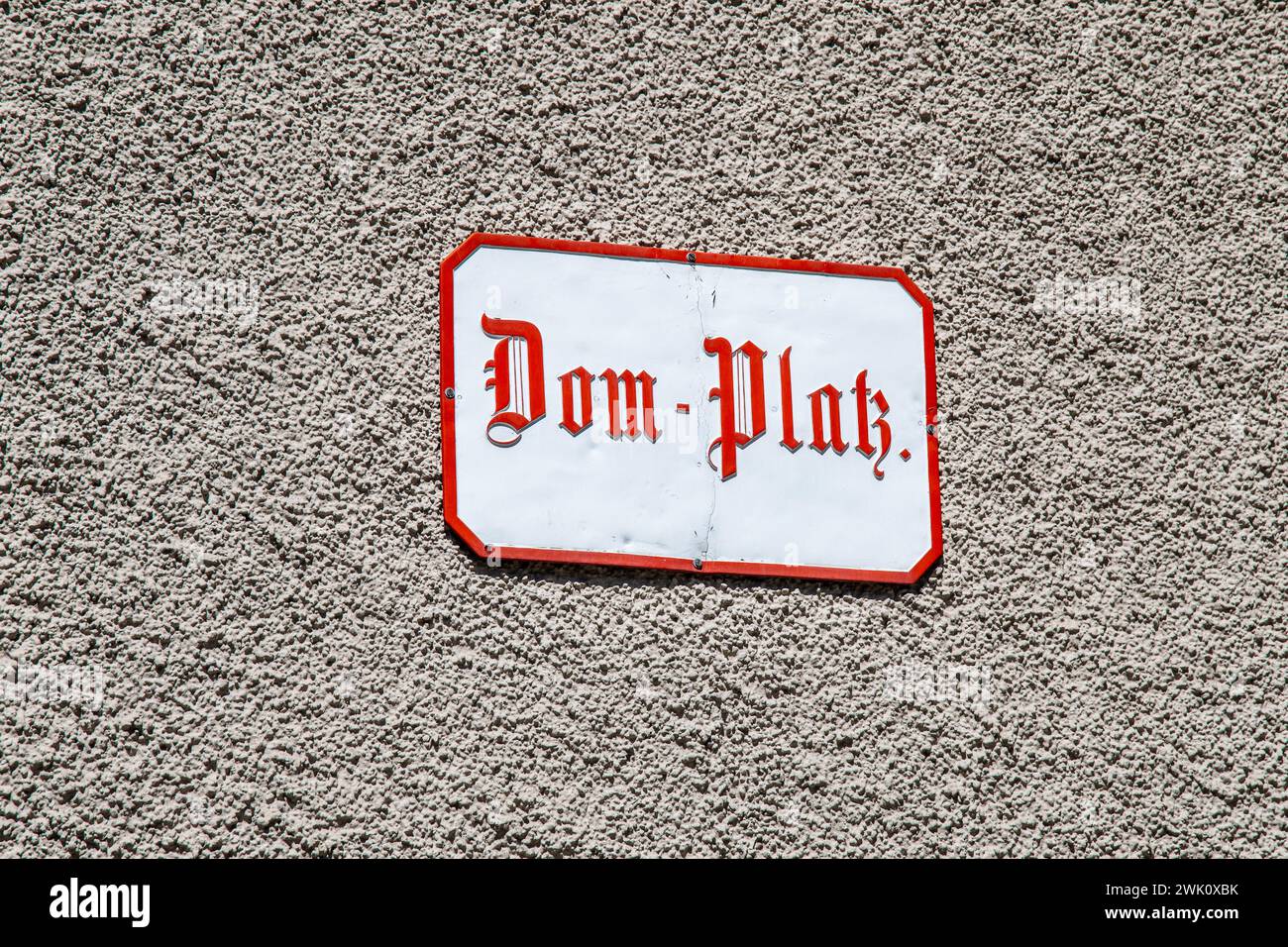 A white sign with the inscription Dom-Platz on a gray house wall. The ...