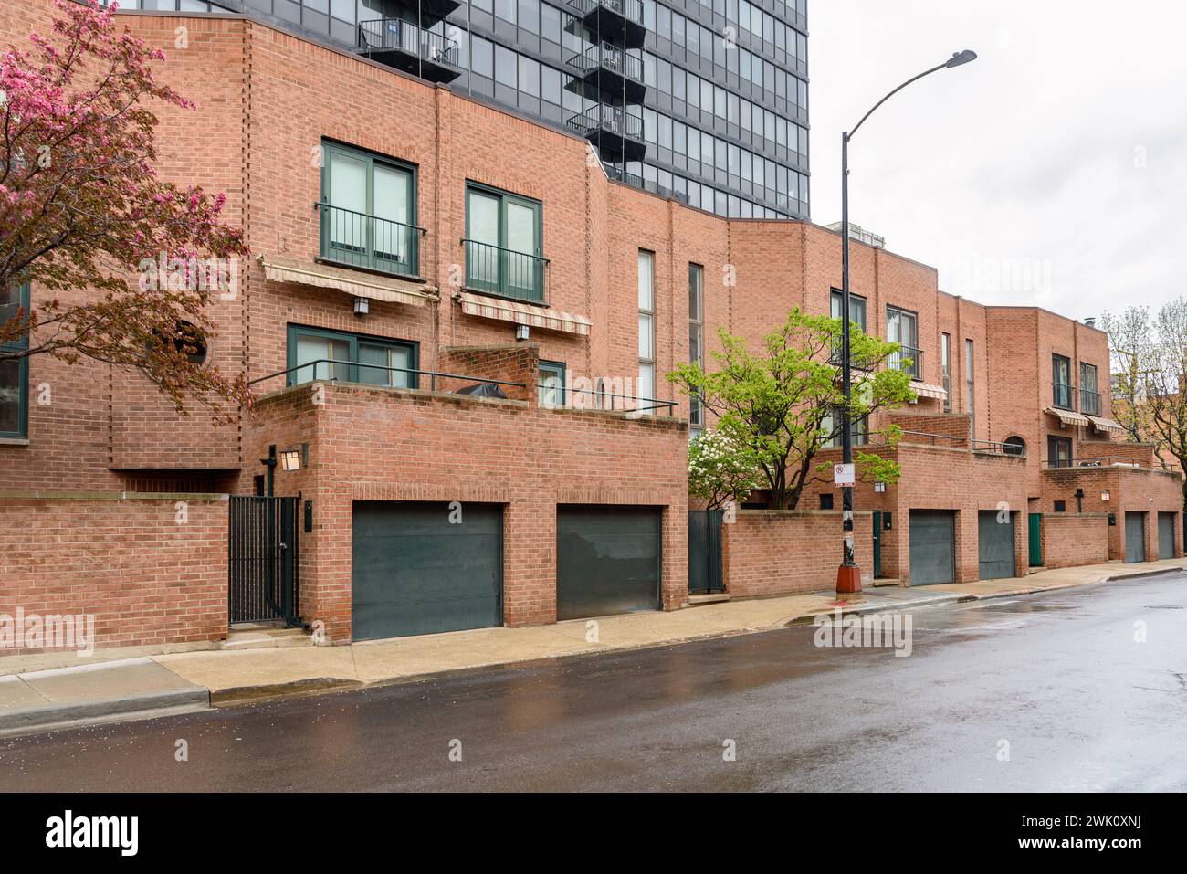 Brick row houses along a street on a cloudy spring day. A glass ...