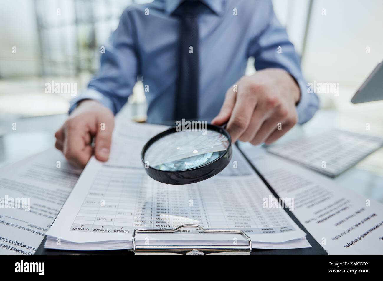 Businessman looking through a magnifying glass to documents Stock Photo ...