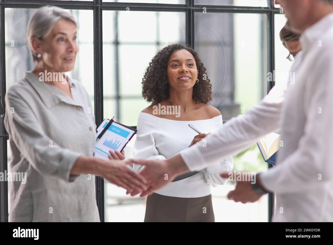 Group of business workers standing together shaking hands at the office ...