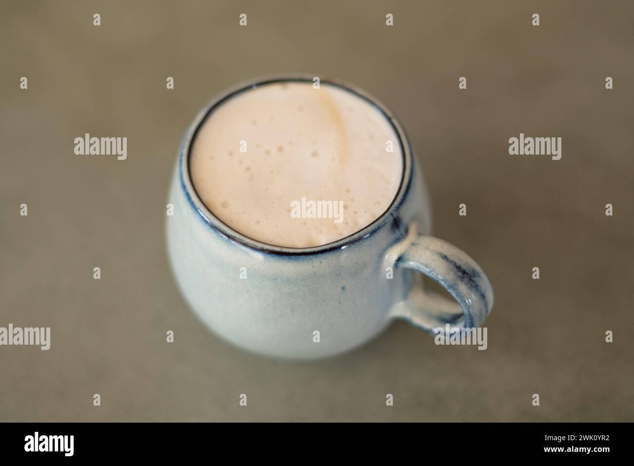 A Blue mug of frothy coffee from above Stock Photo - Alamy