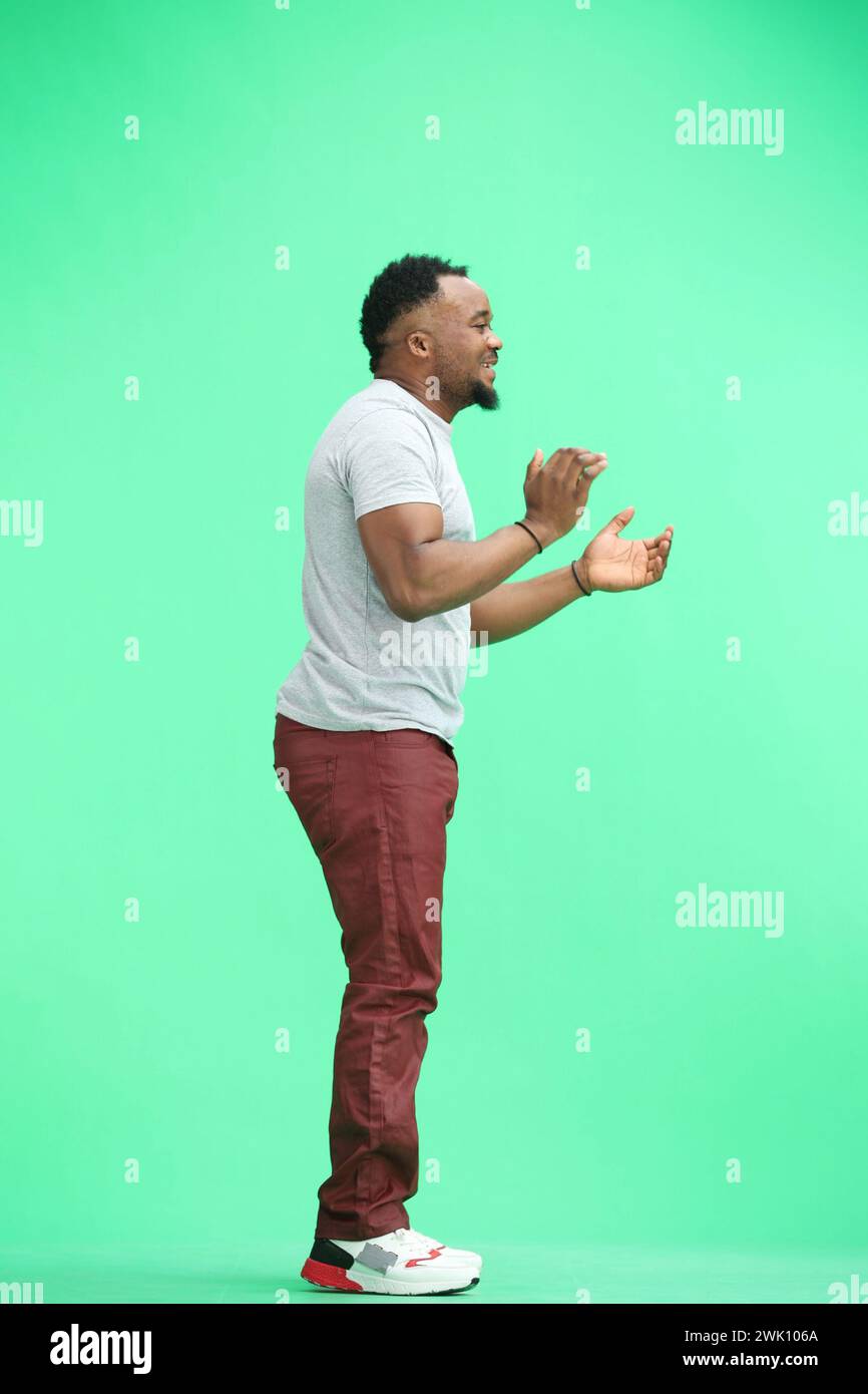 A man, full-length, on a green background, clapping Stock Photo - Alamy