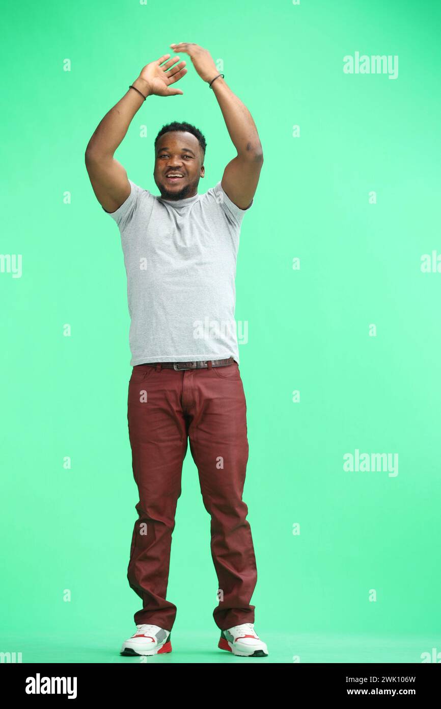 A man, full-length, on a green background, clapping Stock Photo - Alamy