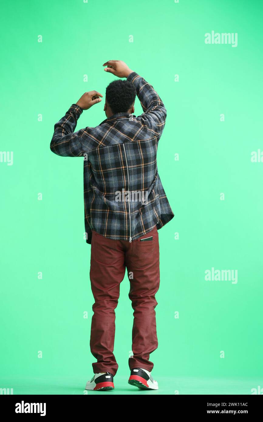 A man, full-length, on a green background, waving his arms Stock Photo ...