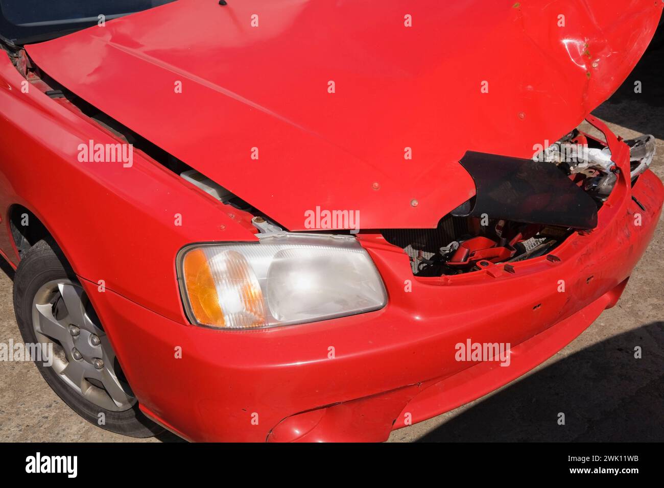 Close-up of red automobile with flat tire and damaged motor compartment ...