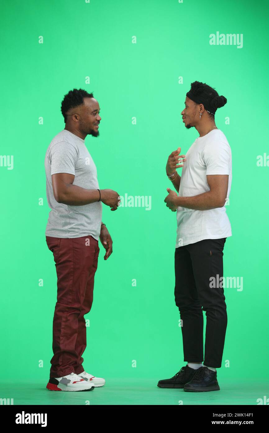 Men, in full height, on a green background, talking Stock Photo - Alamy