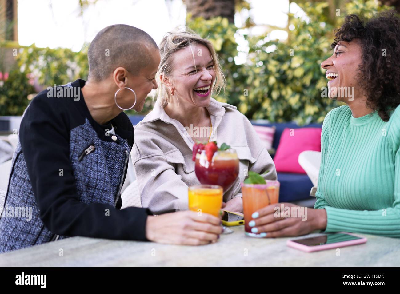 Cheerful gathering mature multi-ethnic female friends laughing outdoor ...