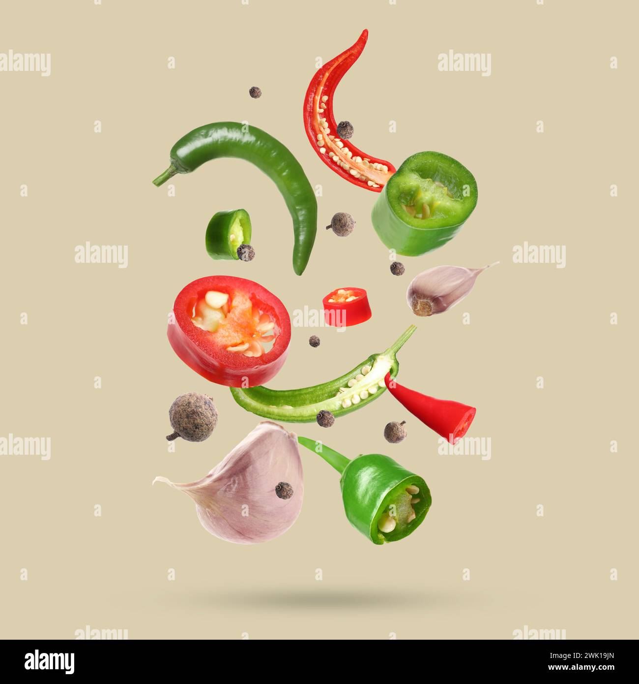 Different spices falling on dark beige background Stock Photo - Alamy