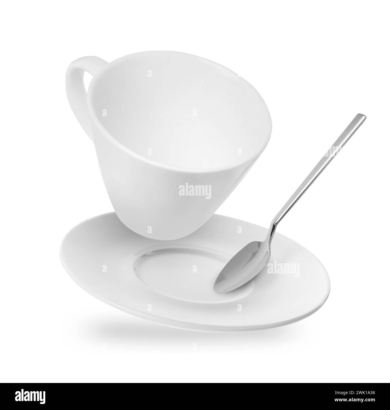 Spoon, cup and saucer falling on white background Stock Photo - Alamy