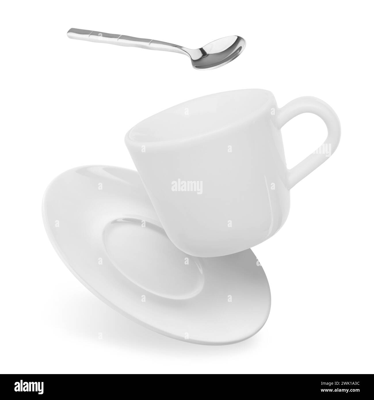 Spoon, cup and saucer falling on white background Stock Photo - Alamy