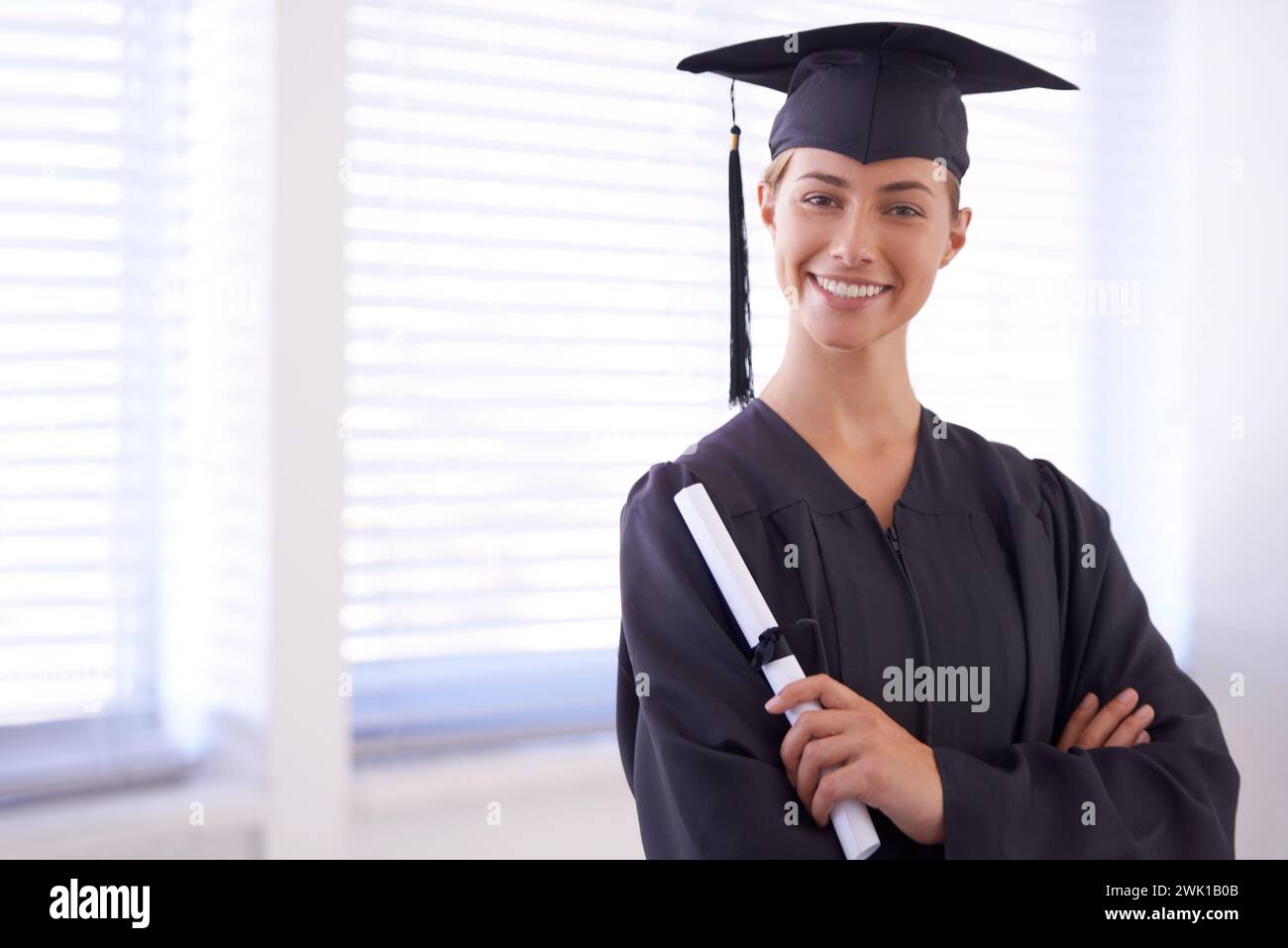 Graduate, diploma and portrait of happy woman with arms crossed at ...