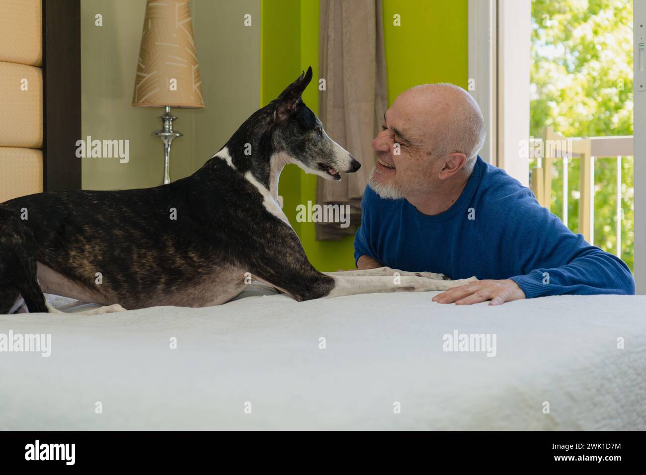 A bald man shares a moment of joy and connection with his pet as they ...