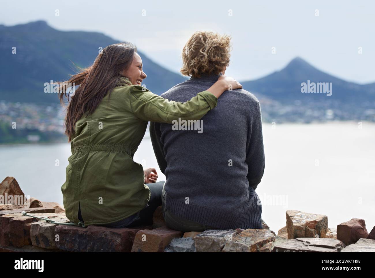 Couple, hug and relax on stone wall for love, support or romance on ...