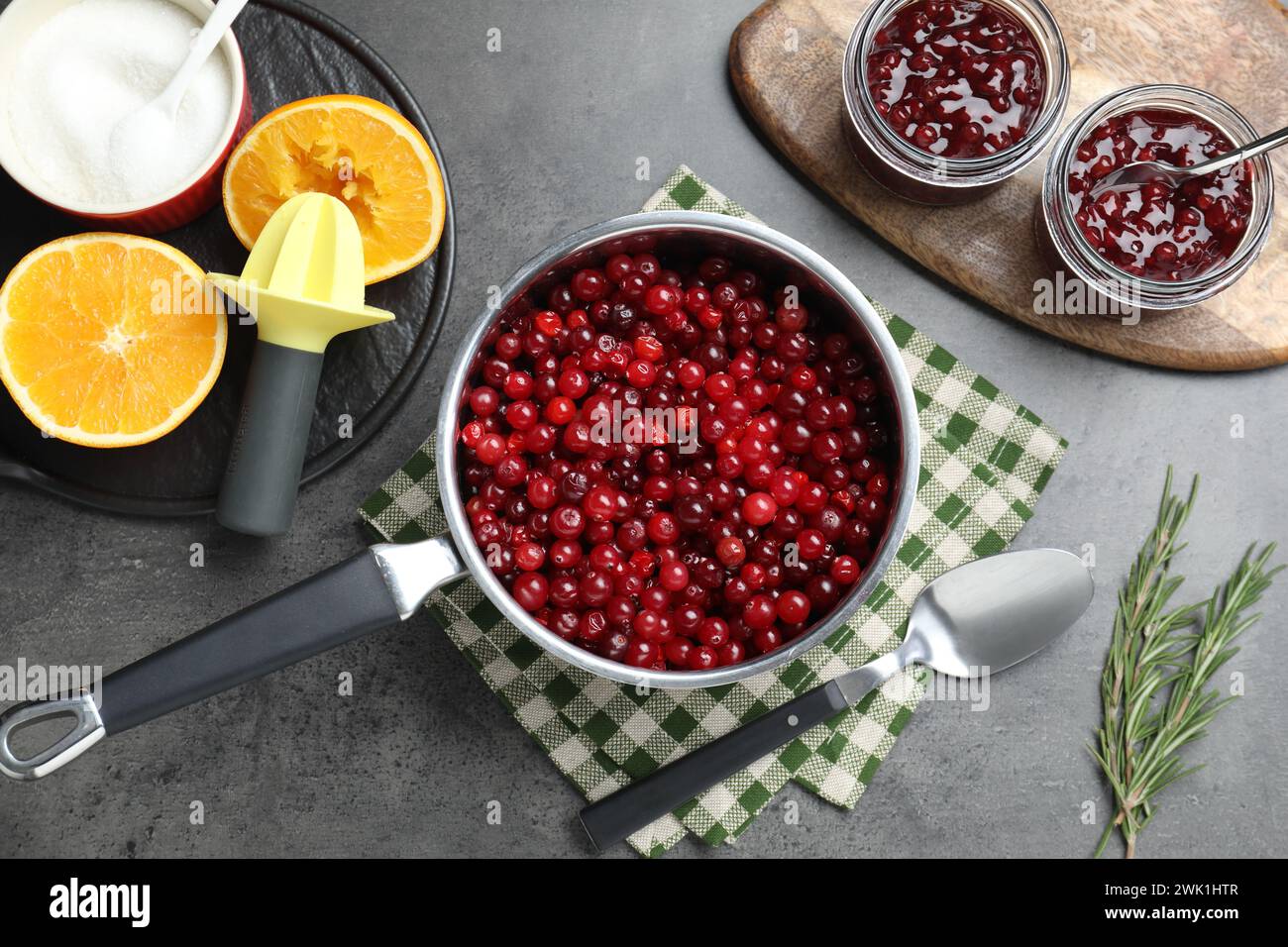 Making cranberry sauce. Fresh cranberries in saucepan and ingredients ...