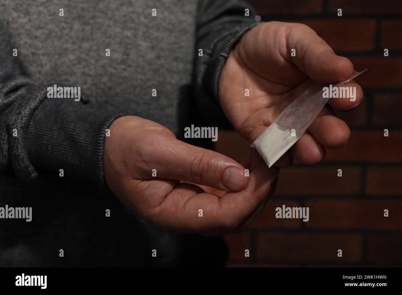 Drug addiction. Man with plastic bag of cocaine on blurred background ...