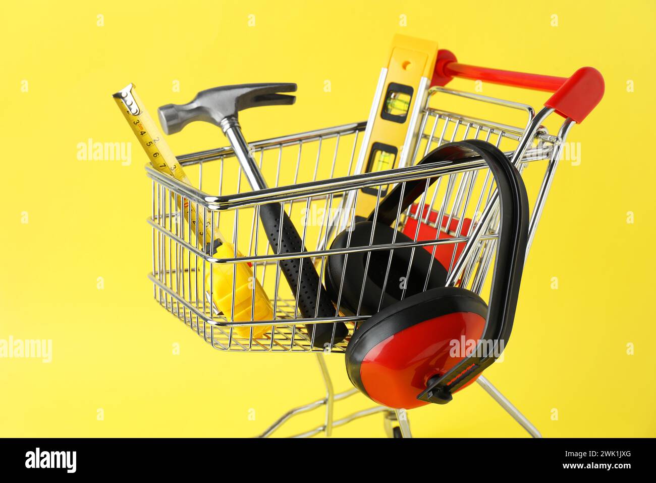 Small shopping cart with set of construction tools and headphones on ...
