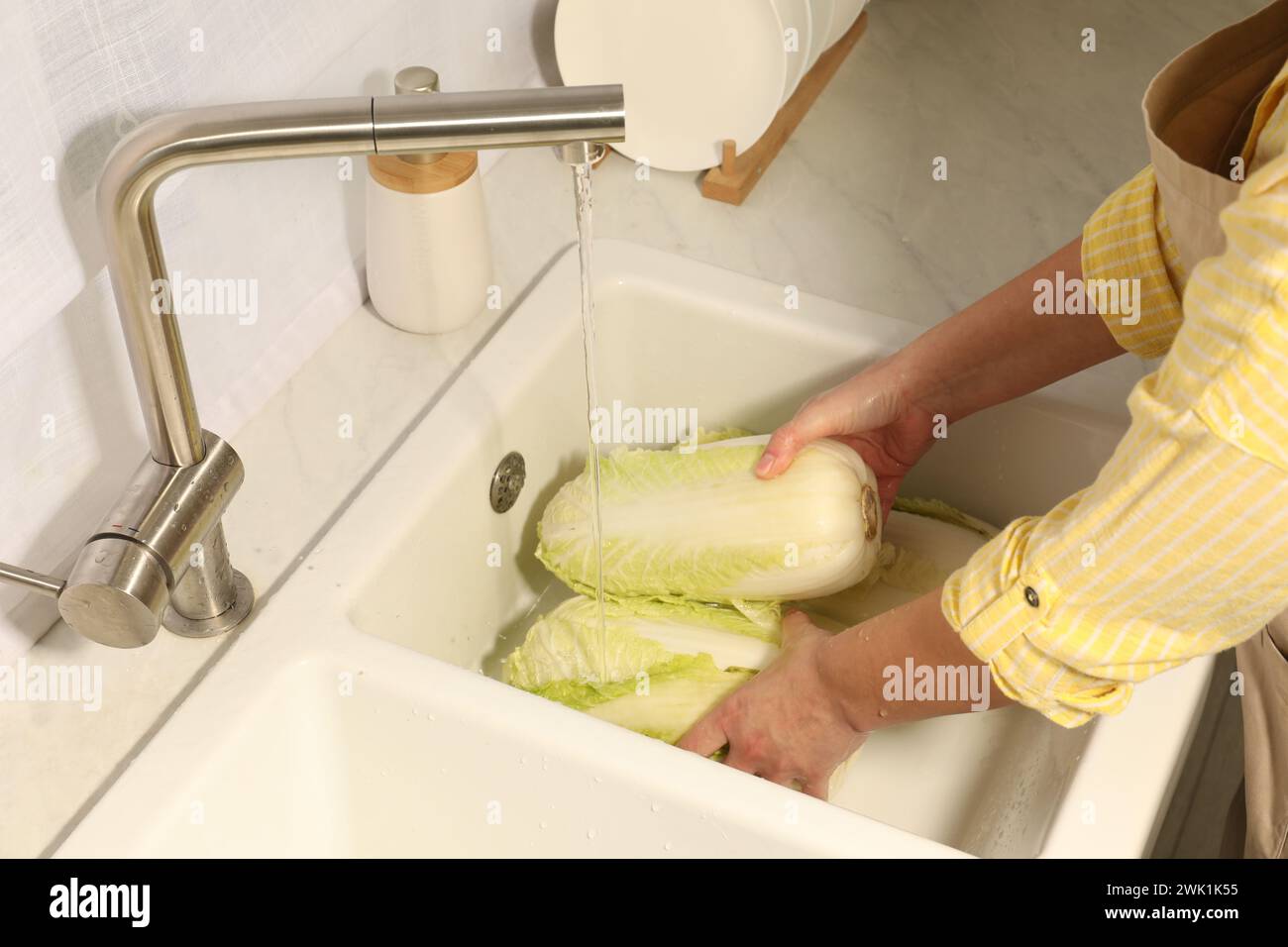 Woman washing fresh chinese cabbage under tap water in kitchen sink, closeup Stock Photo - Alamy