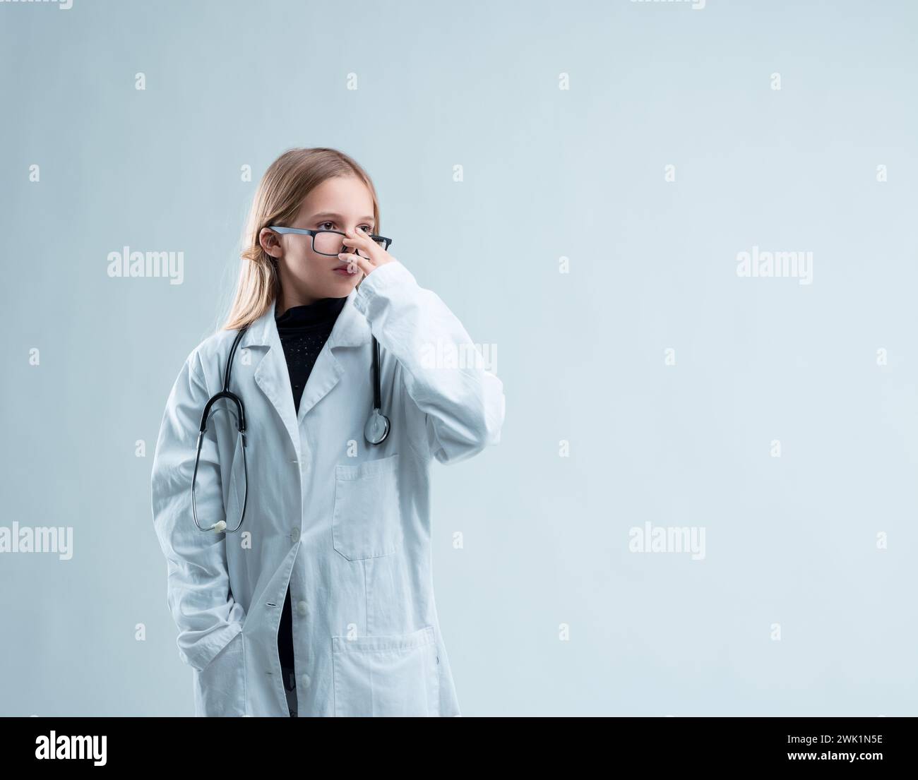The girl, clad in a lab coat and spectacles, portrays a keen interest ...