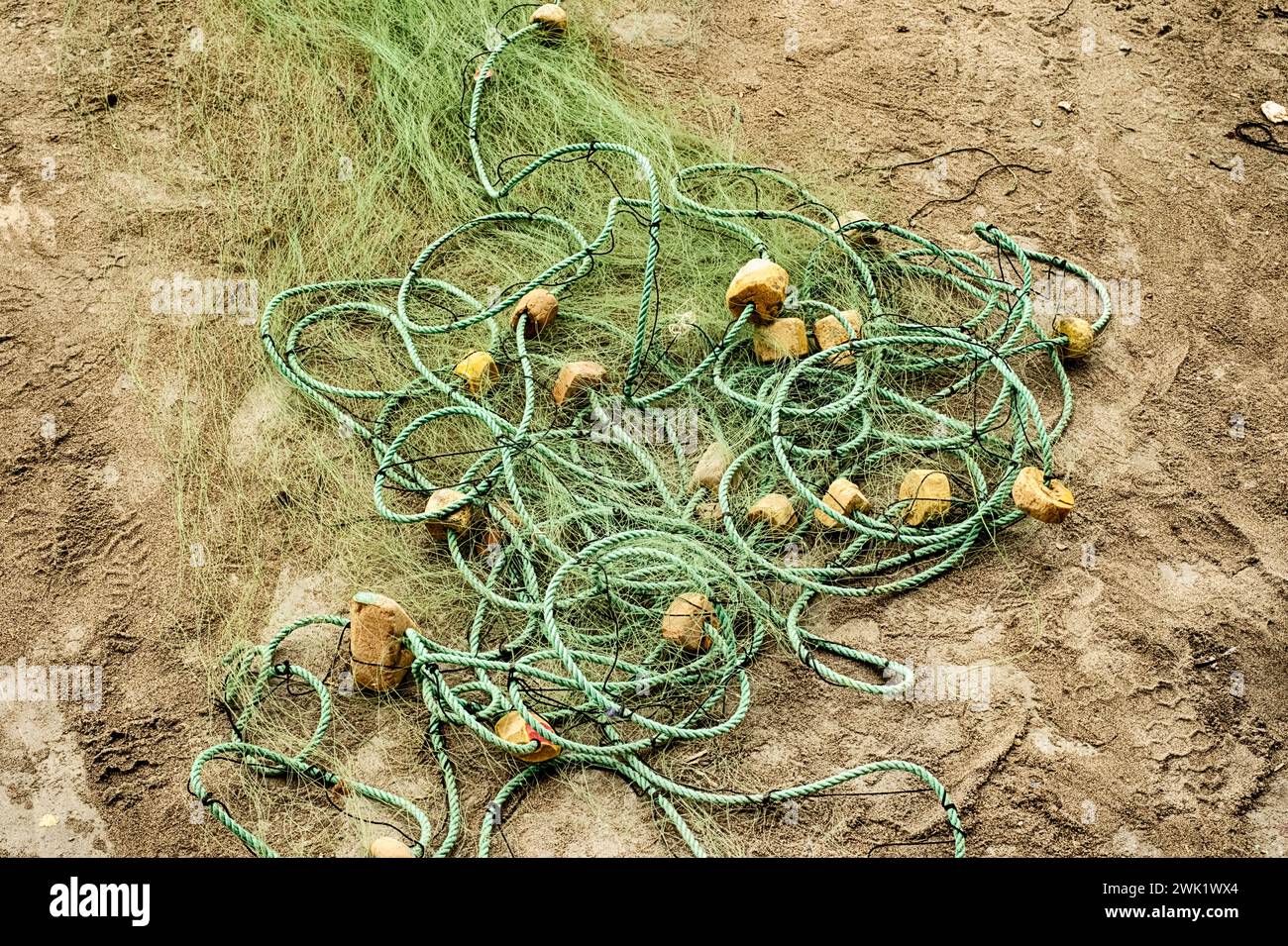 Fish nets and floats are all tangled up in a heap on the beach near the ...