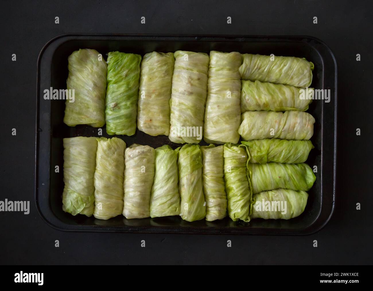 Stuffed cabbage rolls in a baking tray on a black background. Selective ...