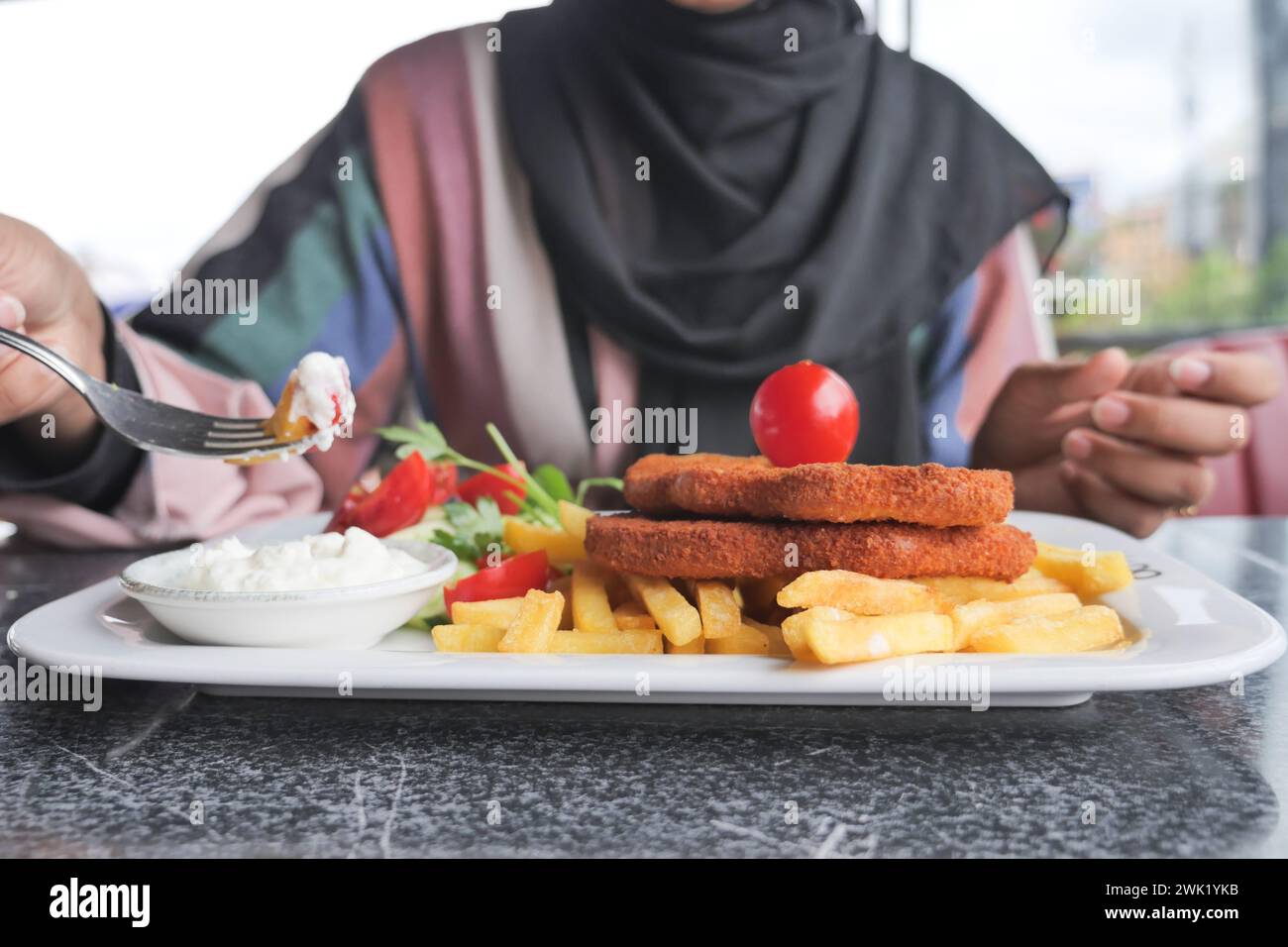 women eating Chicken schnitzel served with potato chips Stock Photo - Alamy