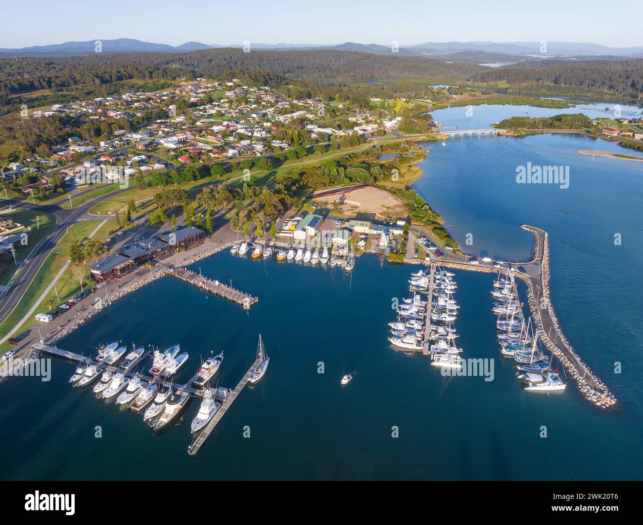 Aerial view of boast moored at a marina behind rocky breakwaters at ...