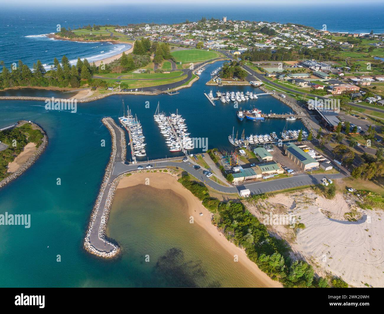Aerial view of boast moored at a marina behind rocky breakwaters at ...