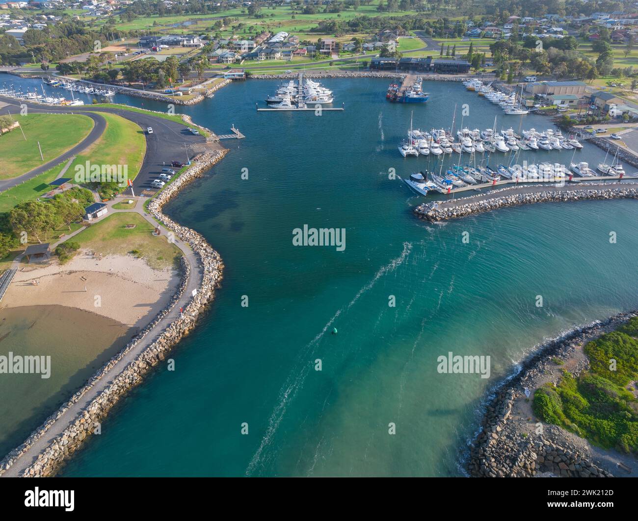 Aerial view of boast moored at a marina behind rocky breakwaters at ...
