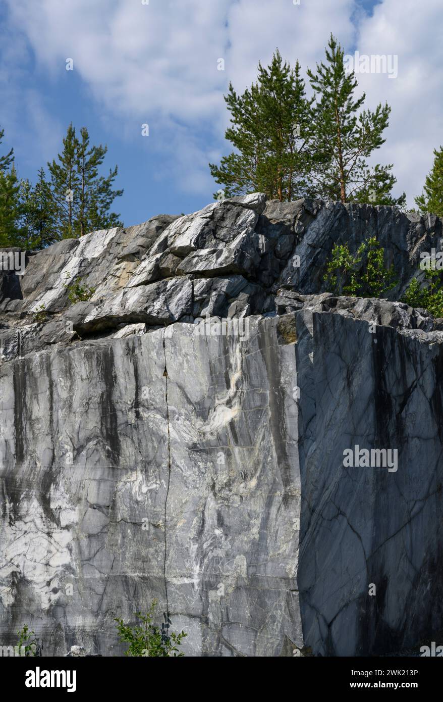 A marble cliff with pine trees on top in the Ruskeala Mountain Park in ...