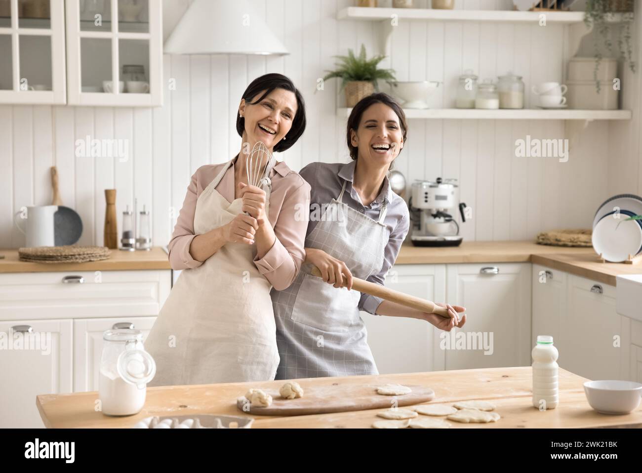 Older mom and grownup daughter singing, cooking in the kitchen Stock ...
