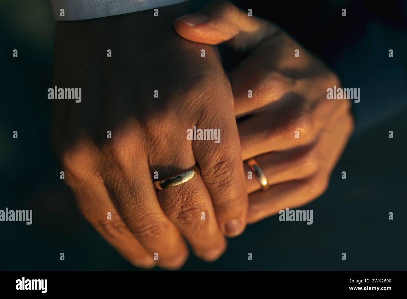 The hands of a couple intertwined with their newly married wedding ...