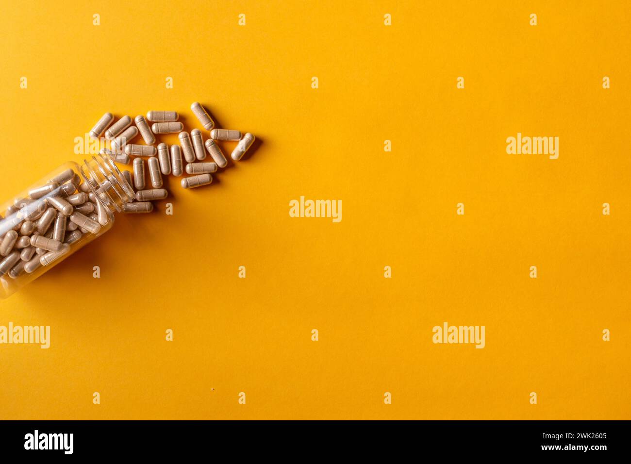 A small stack of white pills on a vibrant orange background ...