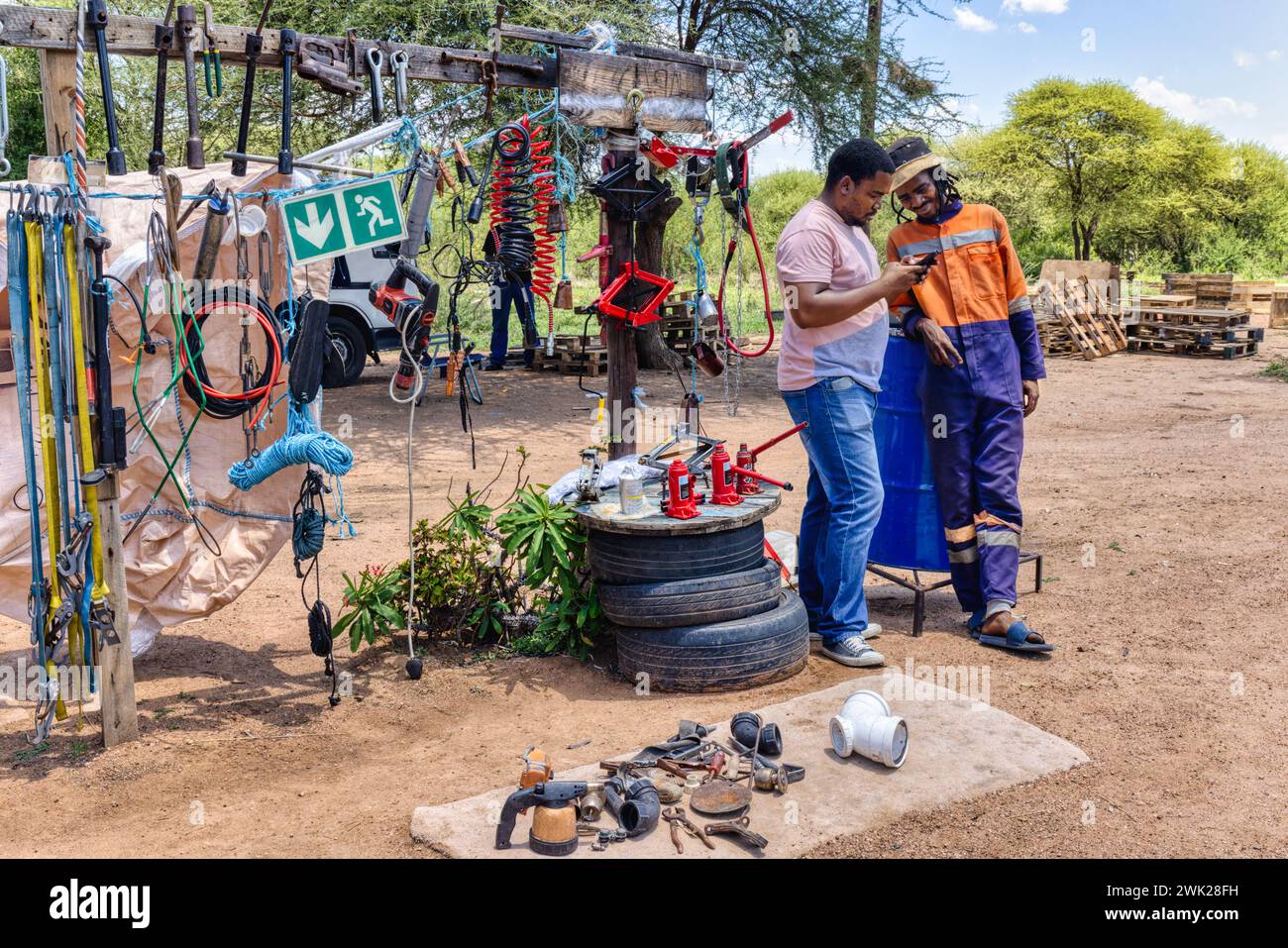 african entrepreneur, street vendor with client on the phone, selling ...