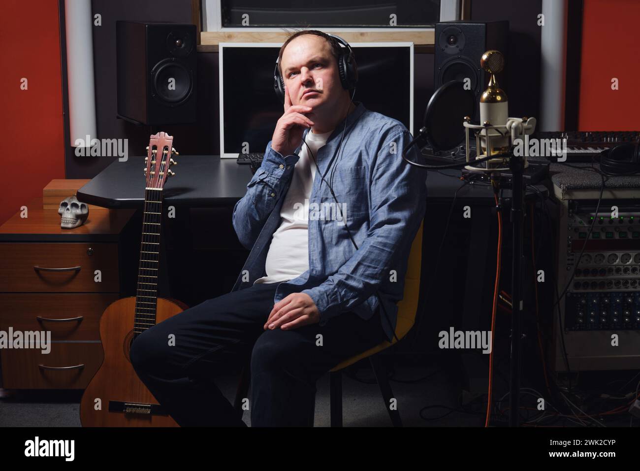 A musician in a thoughtful pose at a recording studio. The workplace of ...
